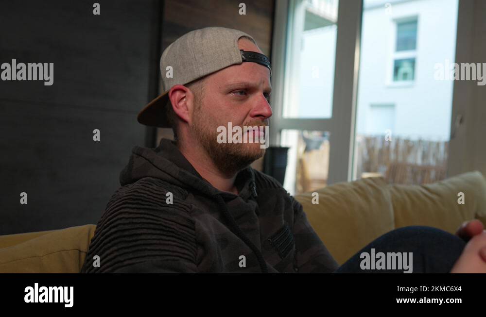 Man watching tv looks sad, depressed, red nose after crying, medium ...