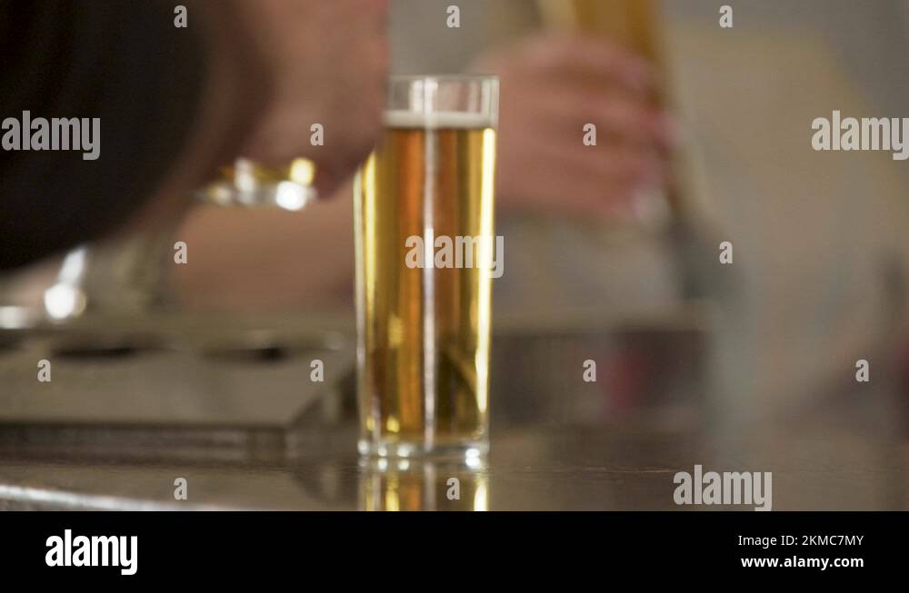 Two people grab a beer from a bar counter Stock Video Footage - Alamy
