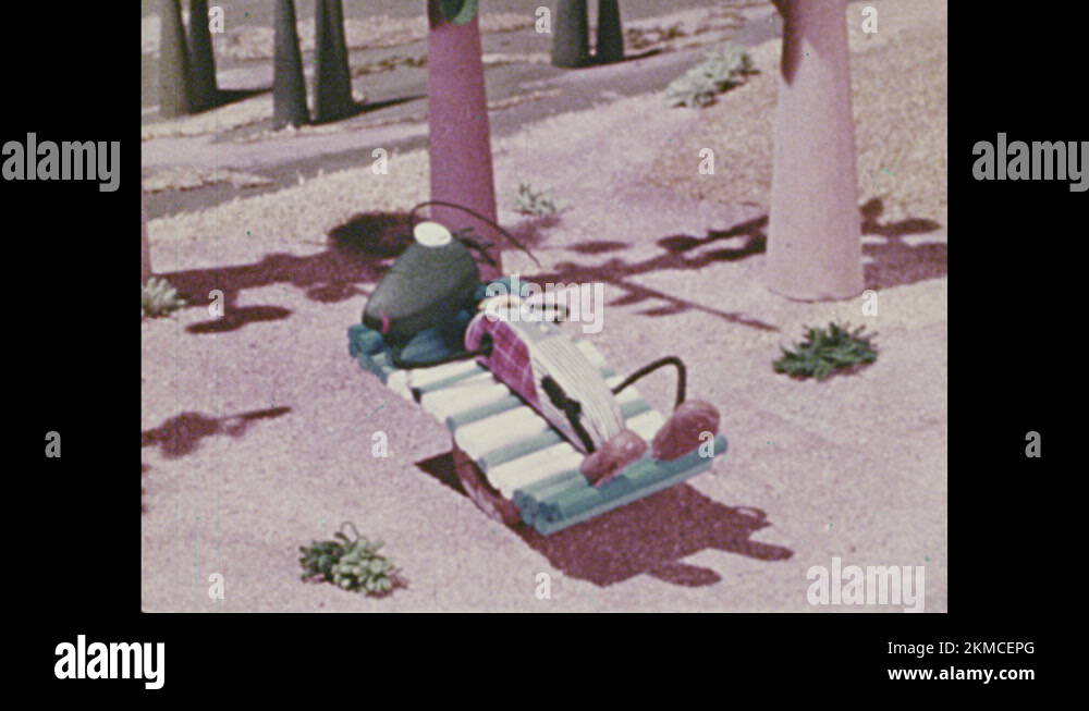 1960s: Stop-motion animation. Grasshopper rests. Ants are busy carrying ...