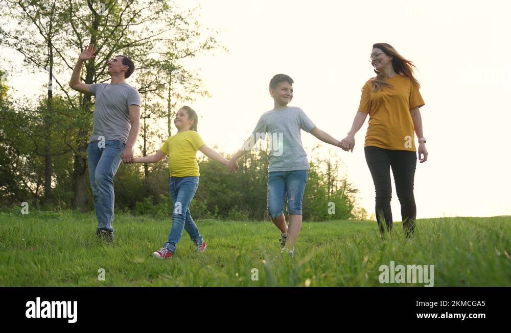 Happy family in park. Group of people walk in field. Parents and ...