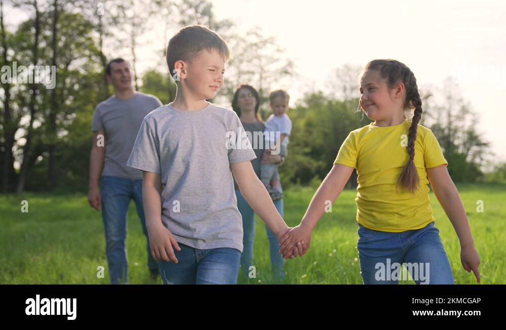 Happy family in park. Group of people walk in field. Parents and ...