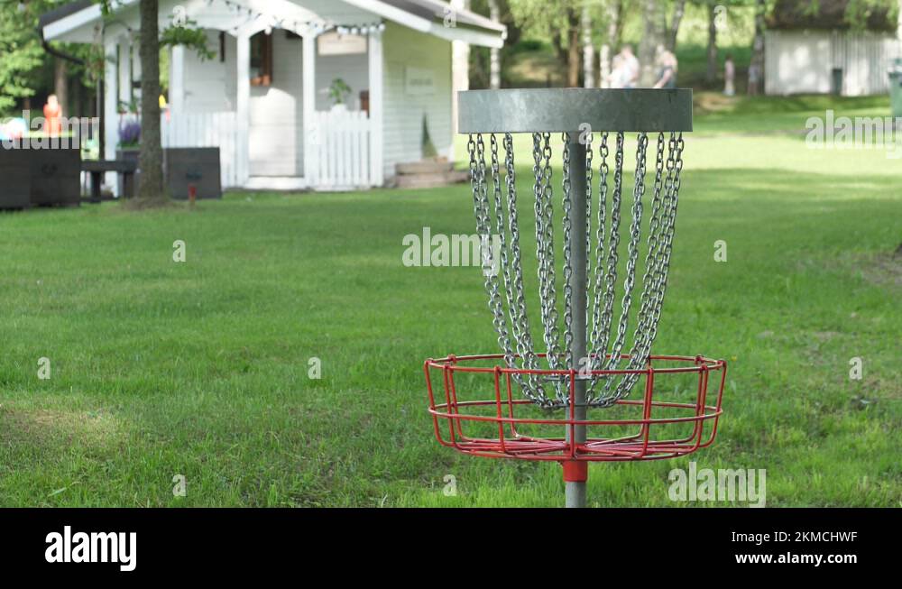 In the park there is a swinging disc golf cart with a green field Stock ...