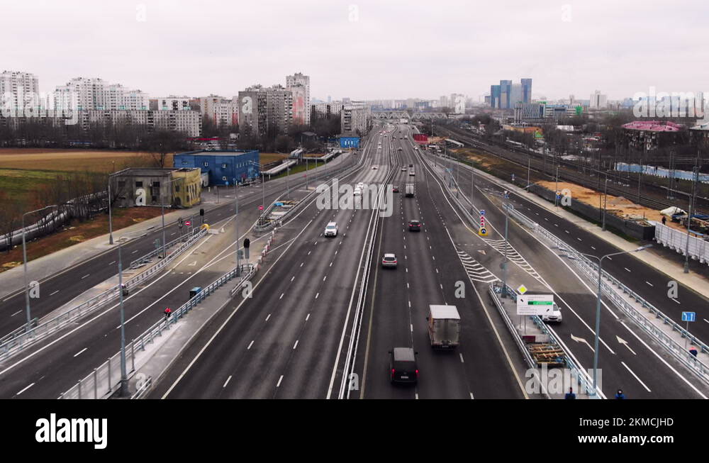 The pathway leads to the city. Houses near the road. Many cars are ...