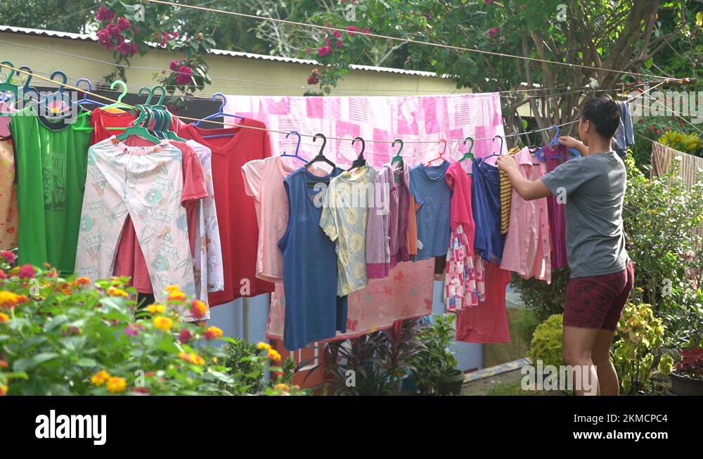 Filipina Lady Doing Household Chores and Drying the Hanging Laundry ...