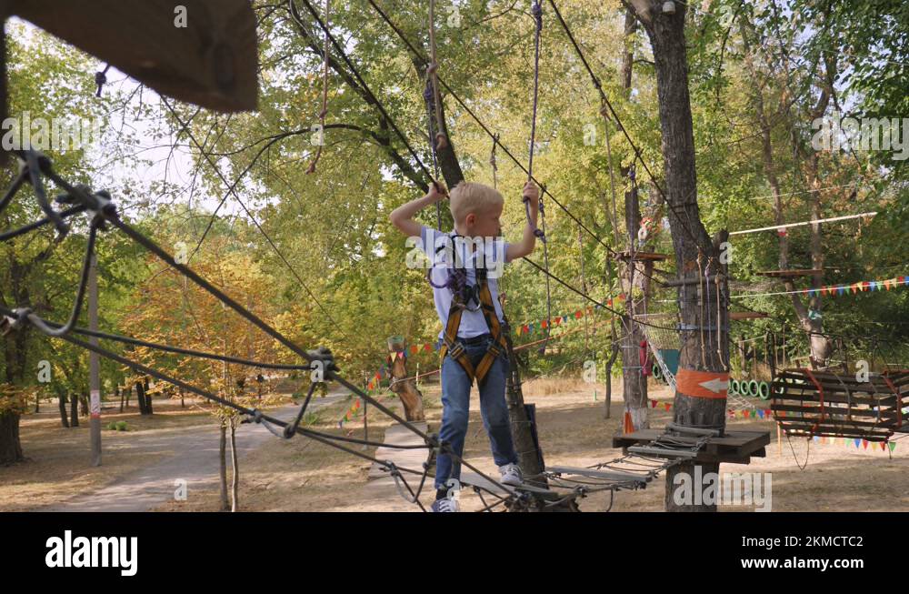 Brave little boy passing the cable route high among trees Stock Video ...