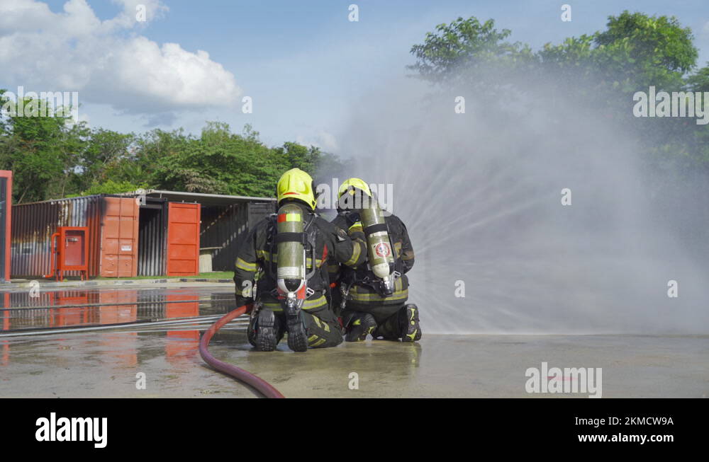 A group of firefighter or fireman with uniform using water fire hose ...
