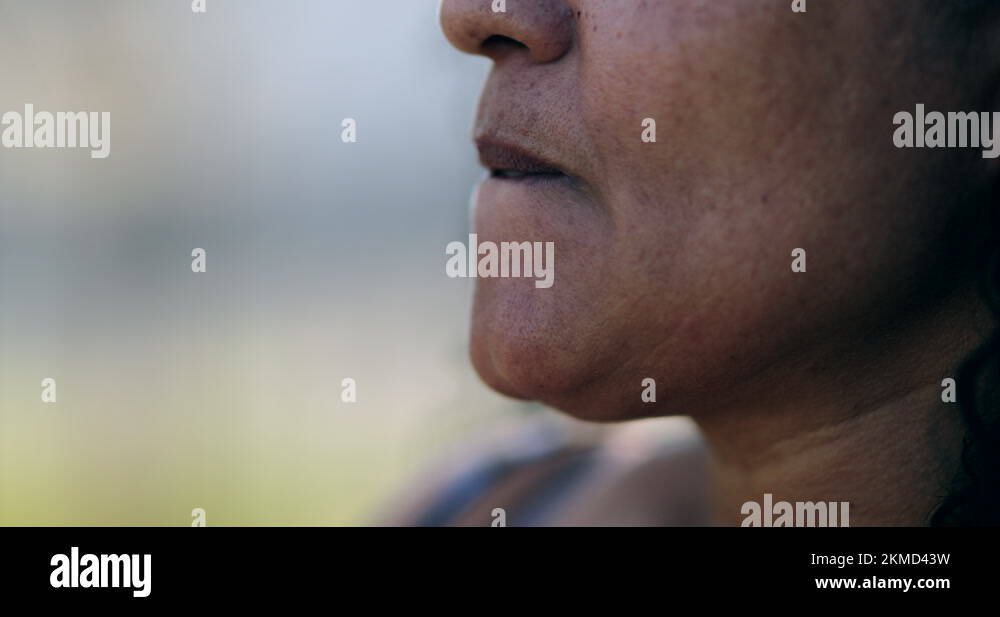 Stressed mature woman smoking cigarette. Anxious person biting lip ...