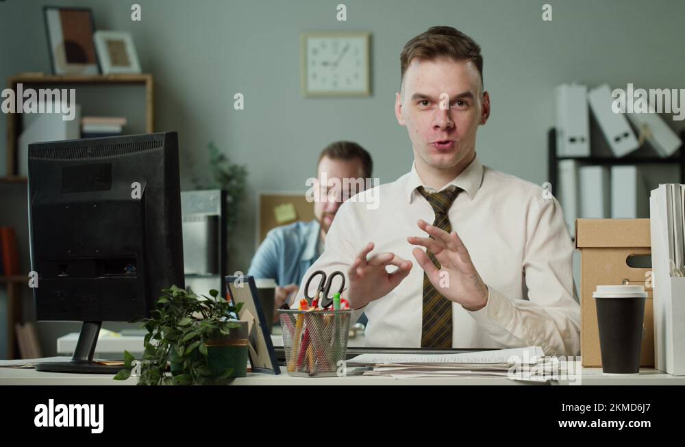 Businessmen sitting and telling funny story with gestures in office ...