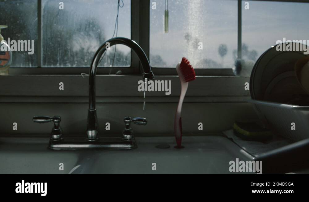 Beautiful cinematic shot of a person turning off a dripping kitchen ...