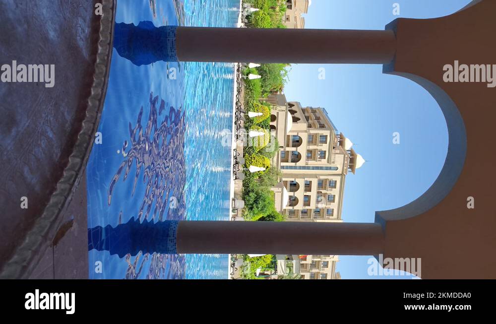 Wind ripples pool water at luxury resort on poolside with Arabic style ...