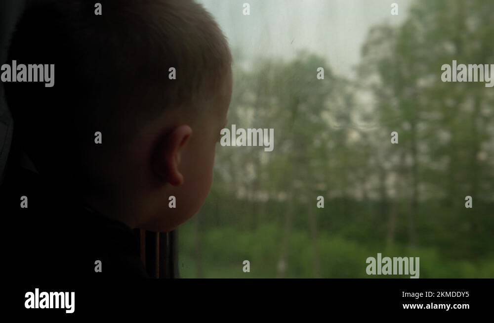 close-up little preschool cute kid boy looking out train window. view ...