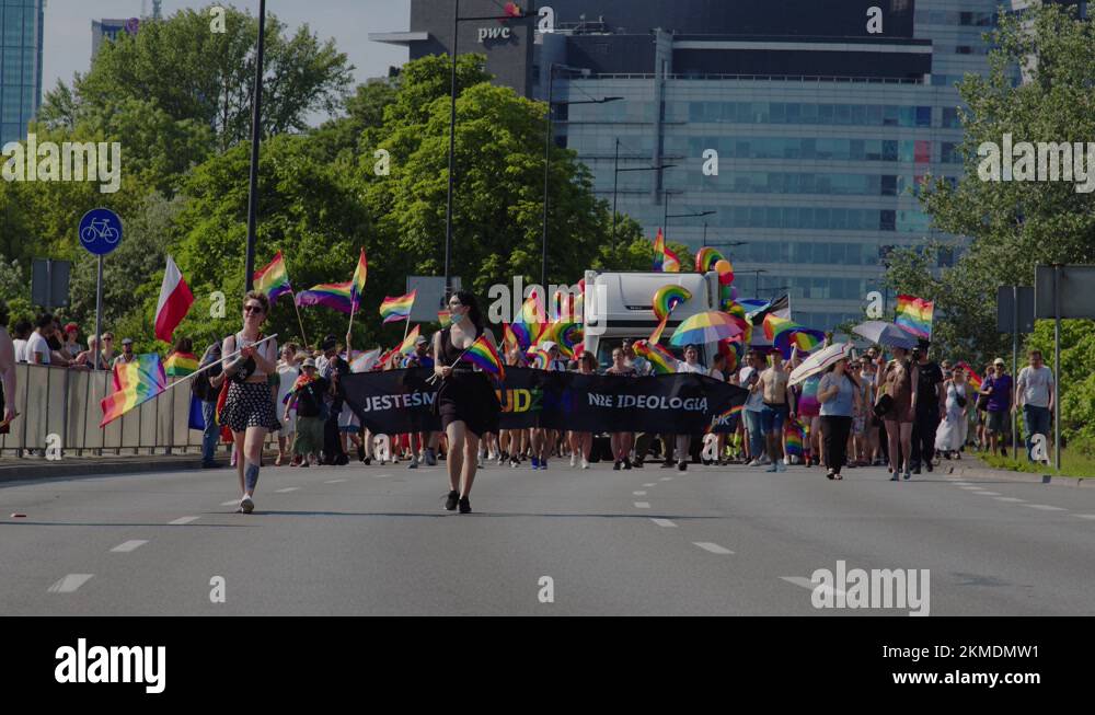 March for LGBTQ rights in a pride parade. People with rainbow flags and ...