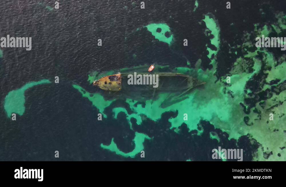 Sunken ship, shipwreck on shallow waters, reef and corals. Ascending ...