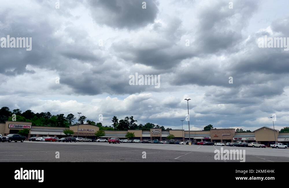 Parking lot view of a retail strip mall plaza Roses various stores ...