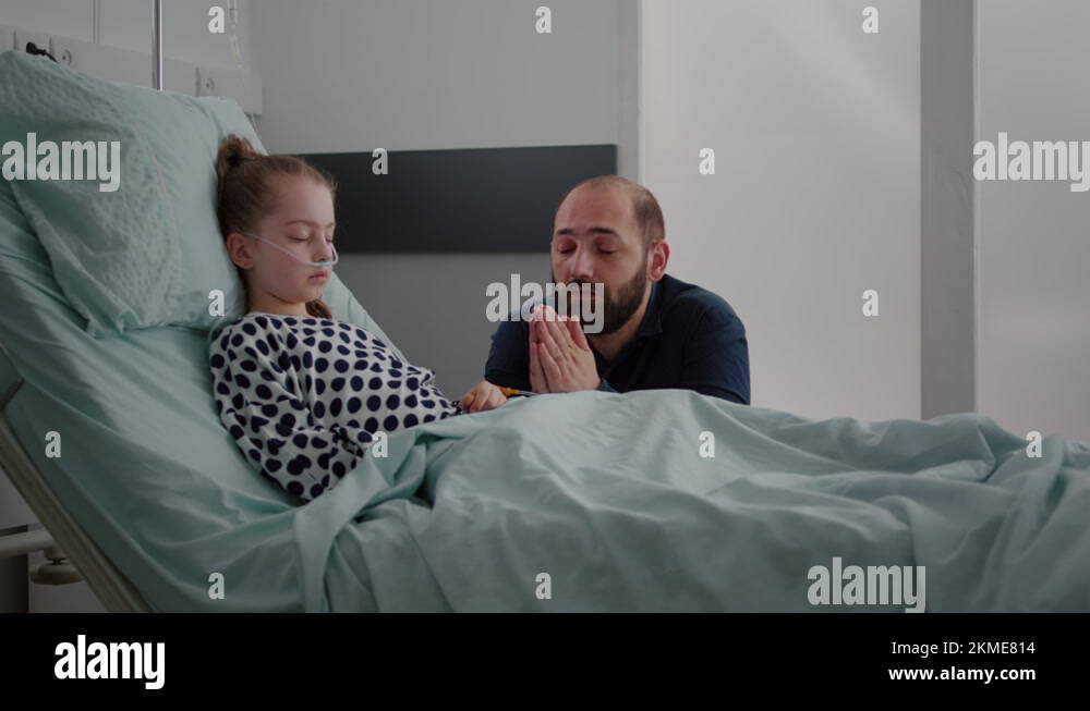 Sick girl daughter sleeping after surgery recovery while worried father praying Stock Video ...