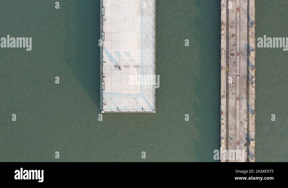 A top down view directly above a concrete pier, next to an older pier ...
