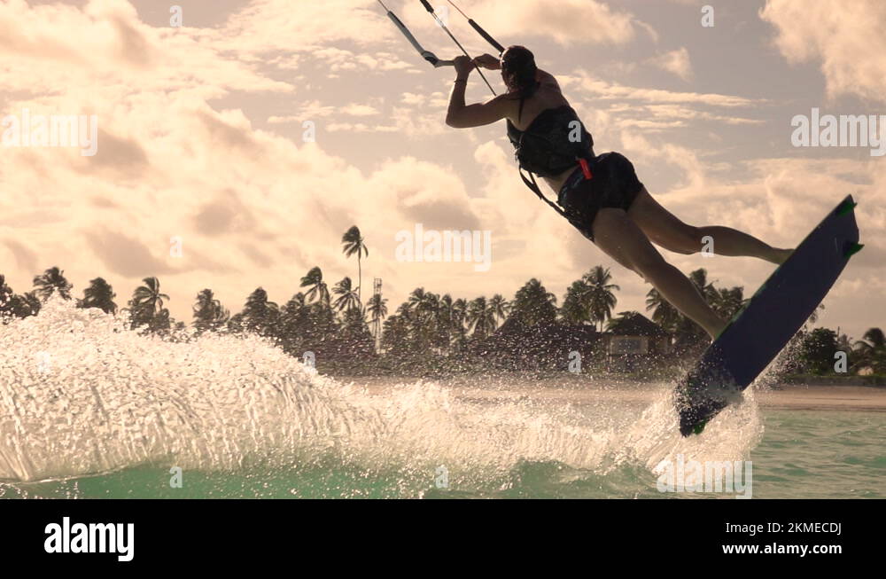 CLOSE UP: Kiteboarder doing a trick high in the air while surfing in ...
