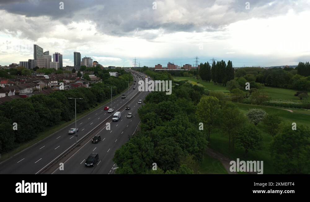 Golf course located next to busy motorway, tall buildings in distance ...