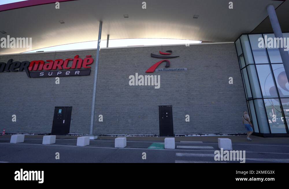 Exterior of the Intermarché Super store in with cars and people passing ...