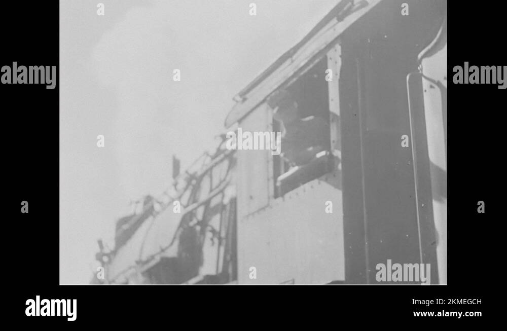 1940s: Engineer leans out window of steam train. Train starts to pull ...
