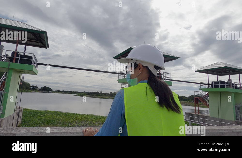 Female engineer wearing a protective mask and safety helmet is works at ...
