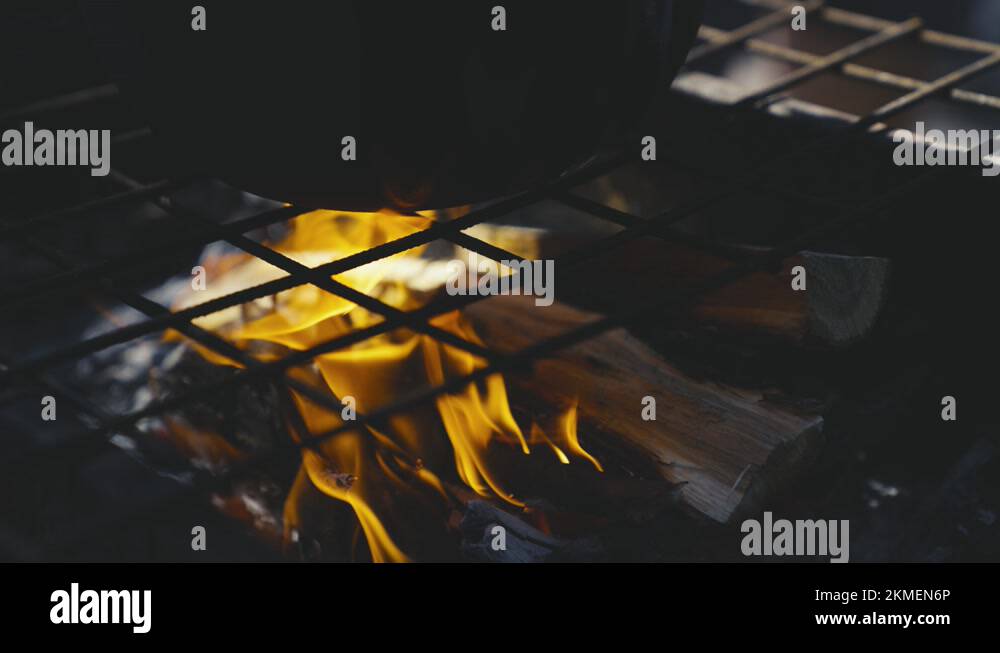 Campfire on the road, cook food on a hot fire in a pot on the grill ...