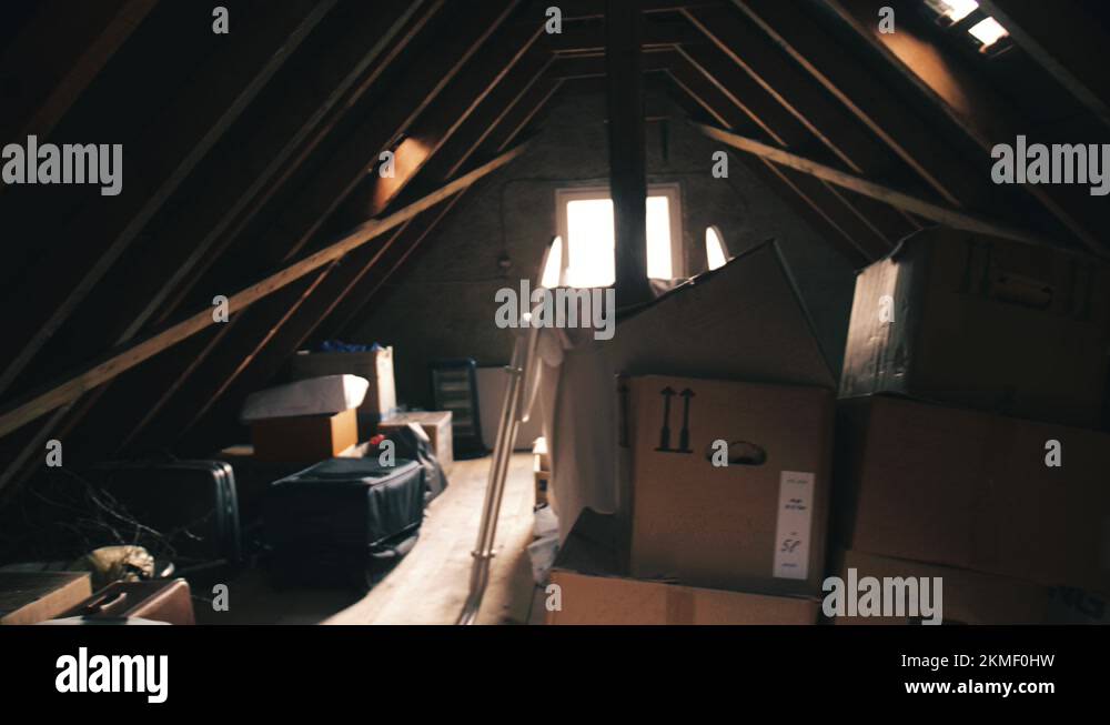 Pan Shot of an old interior vintage gable roof cluttered with boxes and ...
