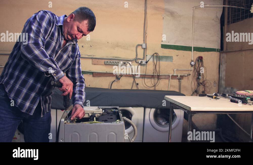 The master uses a screwdriver to fix the front panel with screws Stock ...