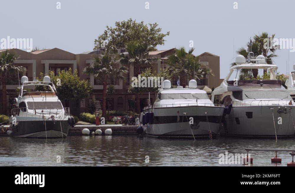 Moored luxury vessels before villas on a modern marina at Sani in ...