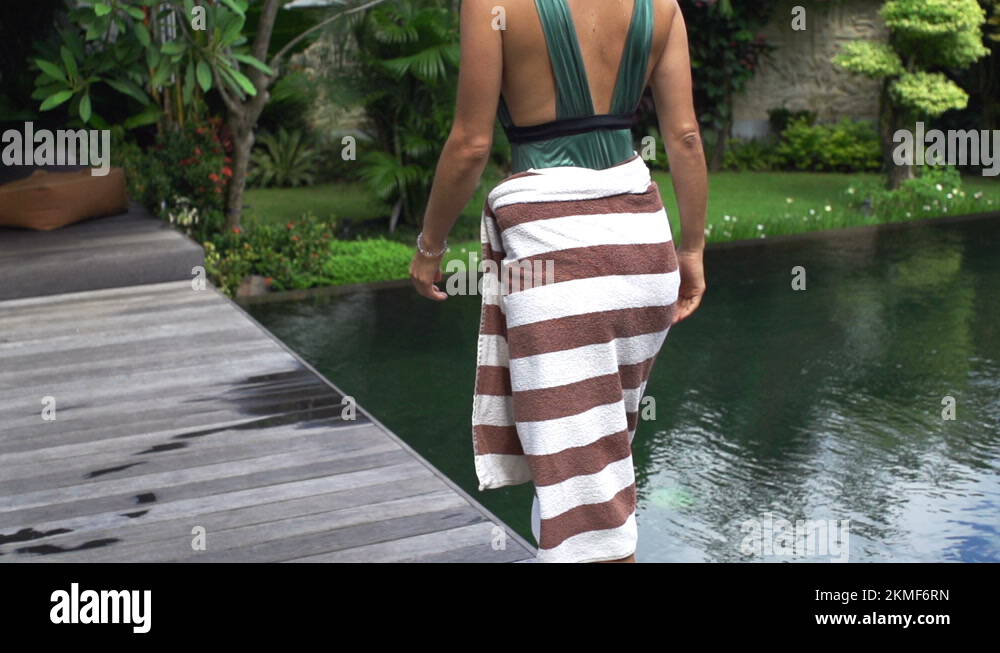 Woman wearing towel walking on edge of swimming pool Stock Video ...
