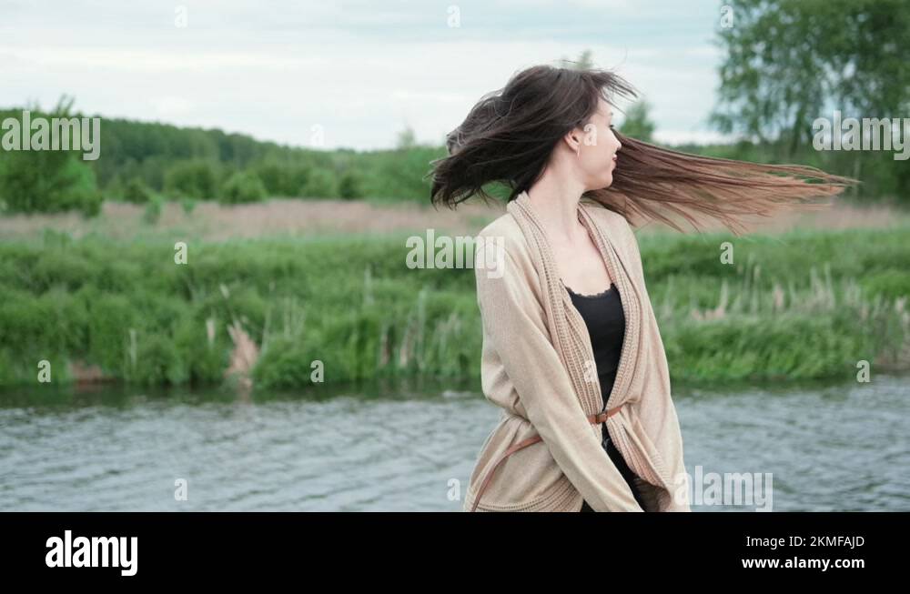 cute attractive woman with long brown hair spinning around near the ...