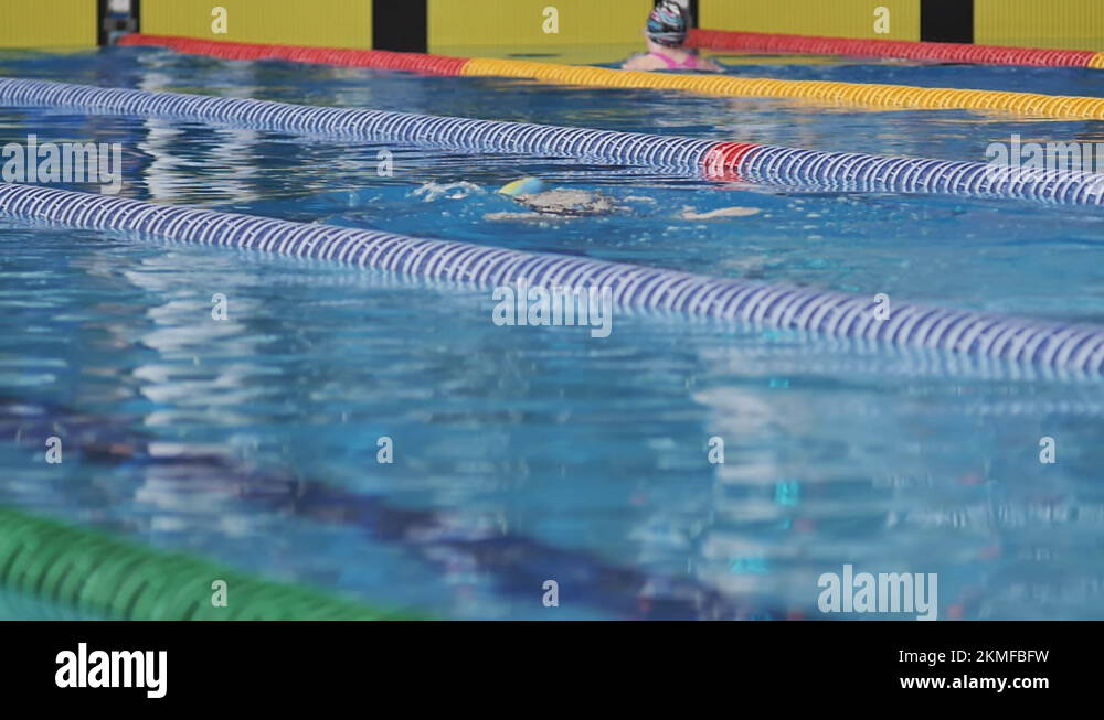 girls swimmers swim in the pool wearing glasses and hats on the ...