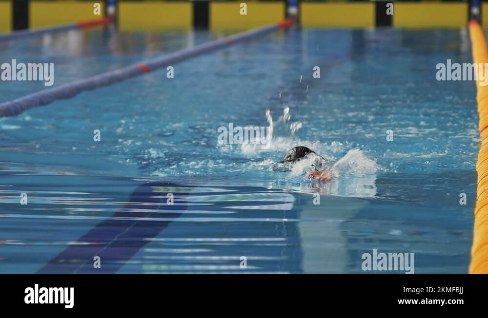 young athlete swimmer swims on his back in the pool during a race on ...