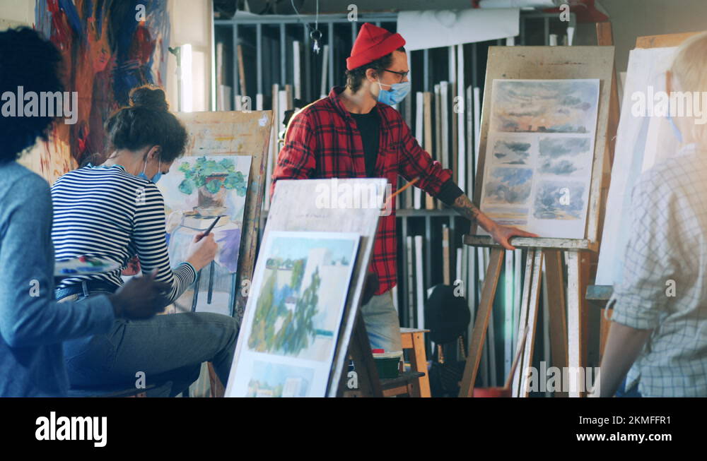 Art education concept. Male painter in a face mask is explaining ...