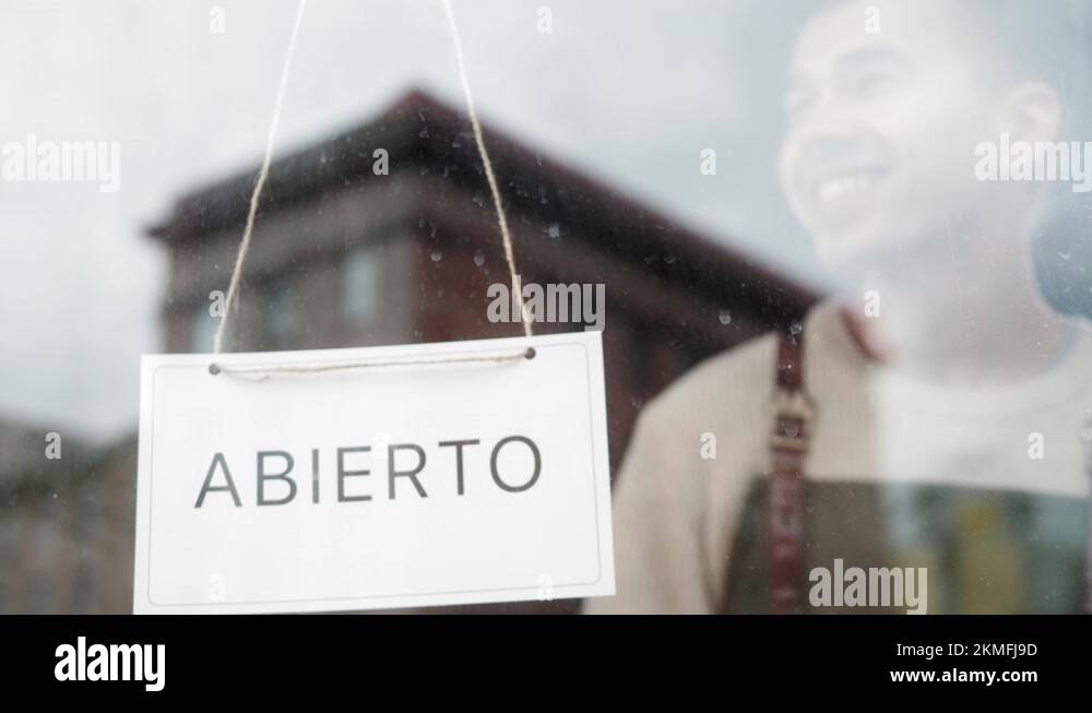 Waiter turn open close sign entrance door while reopening cafe during ...