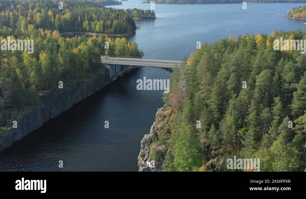 A bridge across the Lake Saimaa with the green trees on the side ...