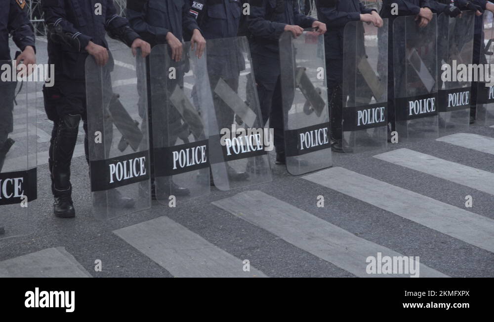 Riot policemen with shields standing in line on street Stock Video ...