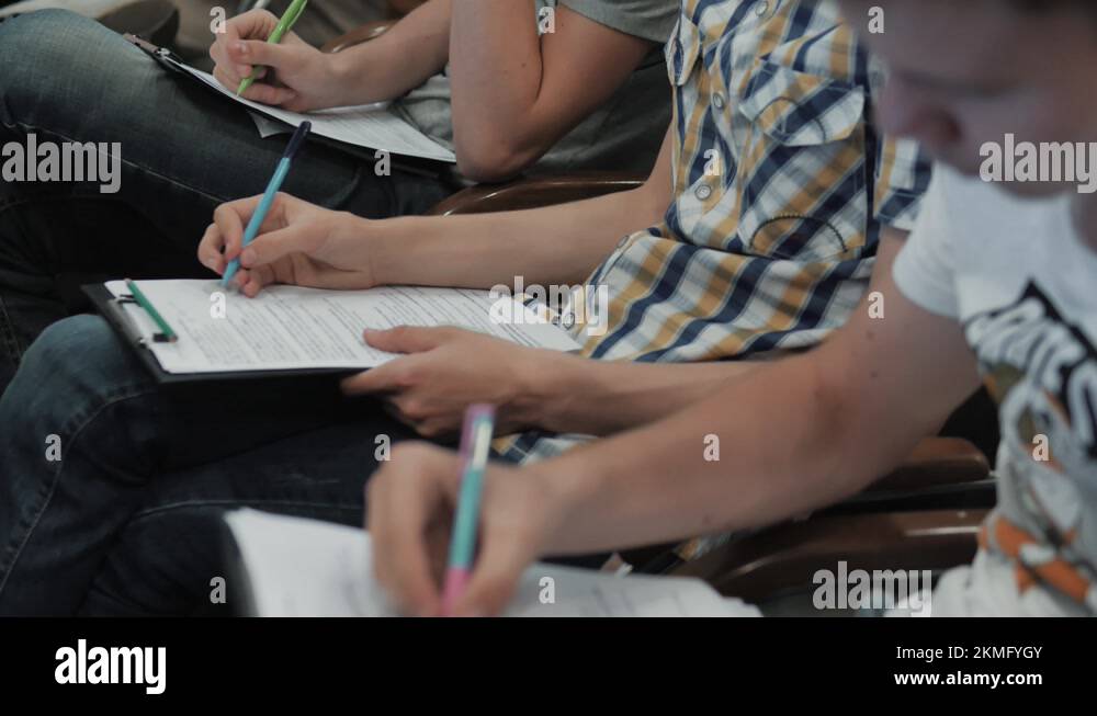 Row of Students in Classroom Taking Exam or Test. Writing in Notebooks ...