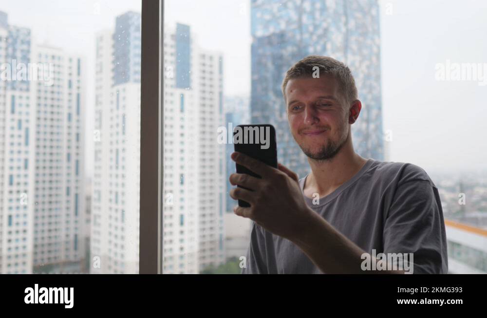 Staying connected to the beloved ones. Young man face timing in his ...