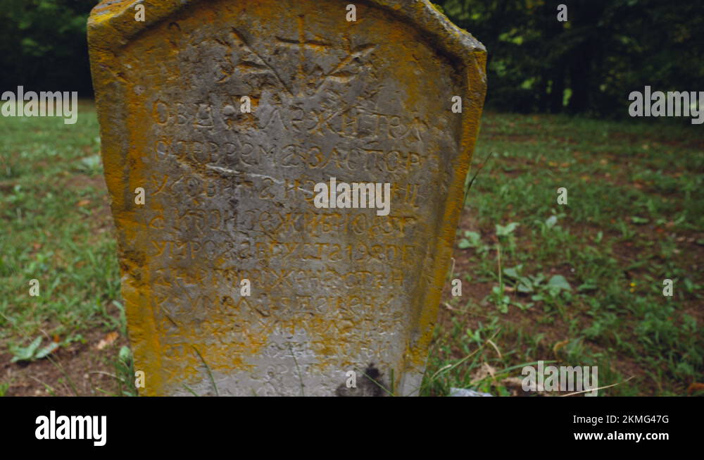 A cinematic panning view of a tombstone of an old Christian grave in ...