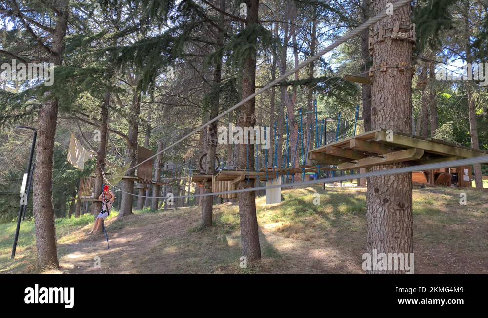Girl child have fun sliding on zip line at kids rope adventure park ...