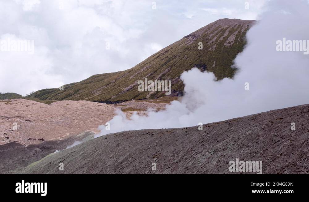 Billowing thick white smoke pouring from Mt Balbi volcano on tropical ...