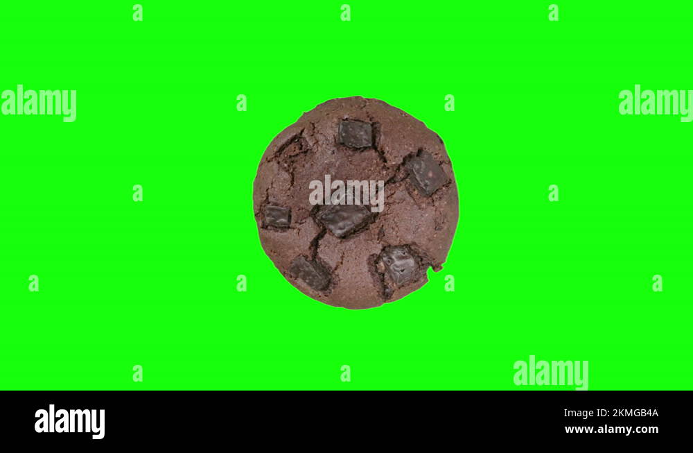 Chocolate fudge cookie spinning on green screen background in top down ...