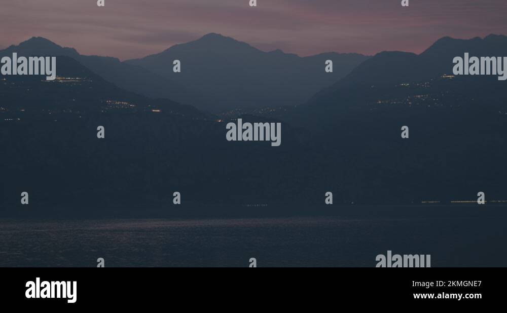 Full shot, Scenic view of lago di garda and city lights on the mountain ...