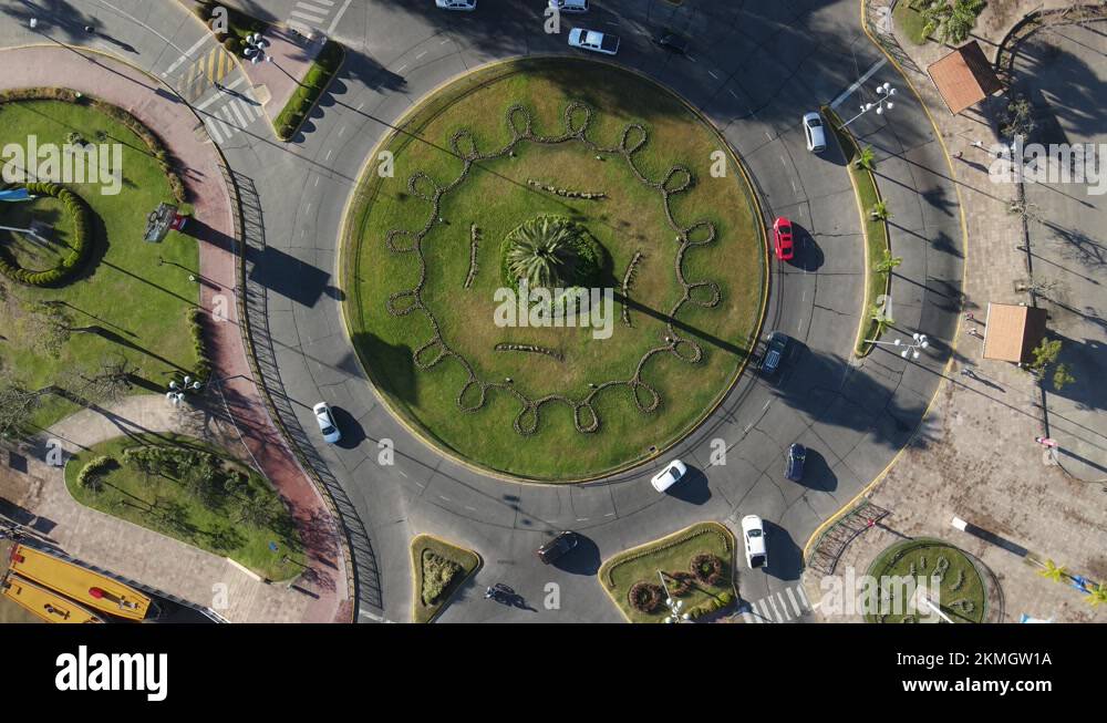 Vehicles on a busy roundabout junction. A green traffic circle with cars Stock Video Footage - Alamy