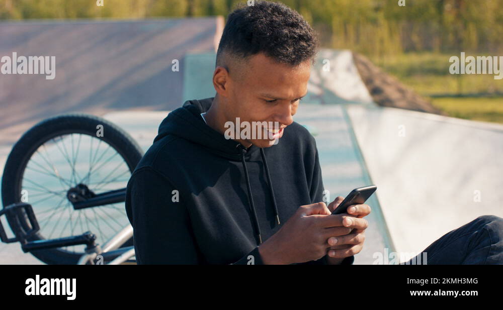 Dark-skinned, handsome, talented man relaxes afternoon on ramps at ...