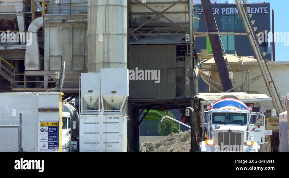Conveyor belt pouring concrete into mixer truck at industrial cement ...