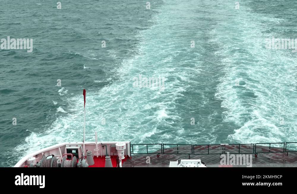 Dolly out on the deck, a wake of waves from a passengers and vehicles ...