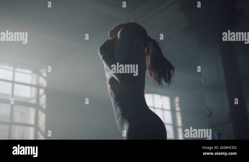 Girl performing exercises to warm up neck. Muscular woman stretching ...