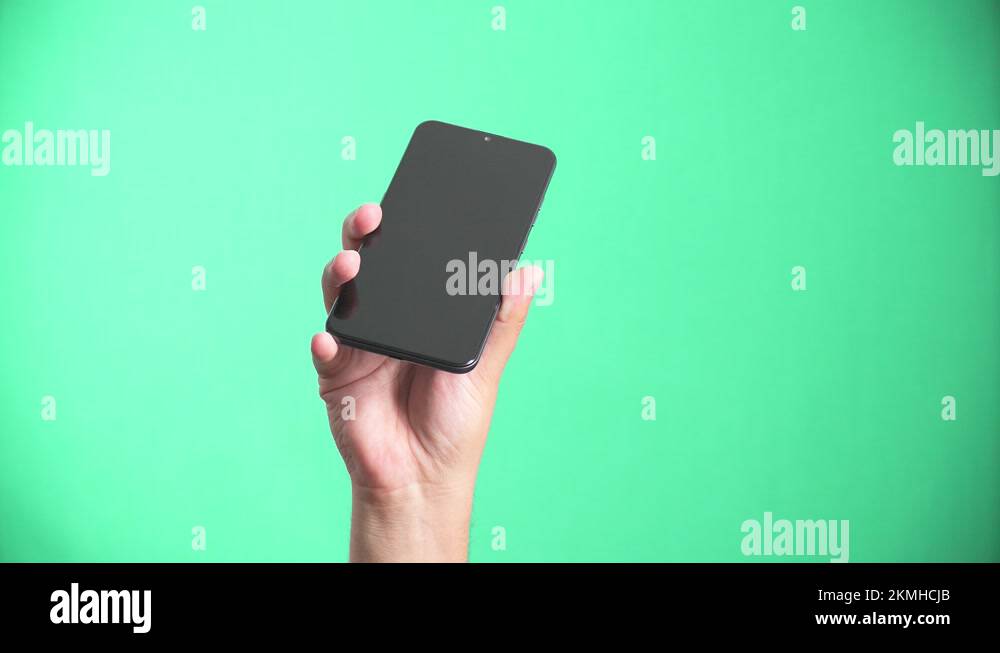 A person holding a cell phone with his hand vertically. 4k Green screen ...